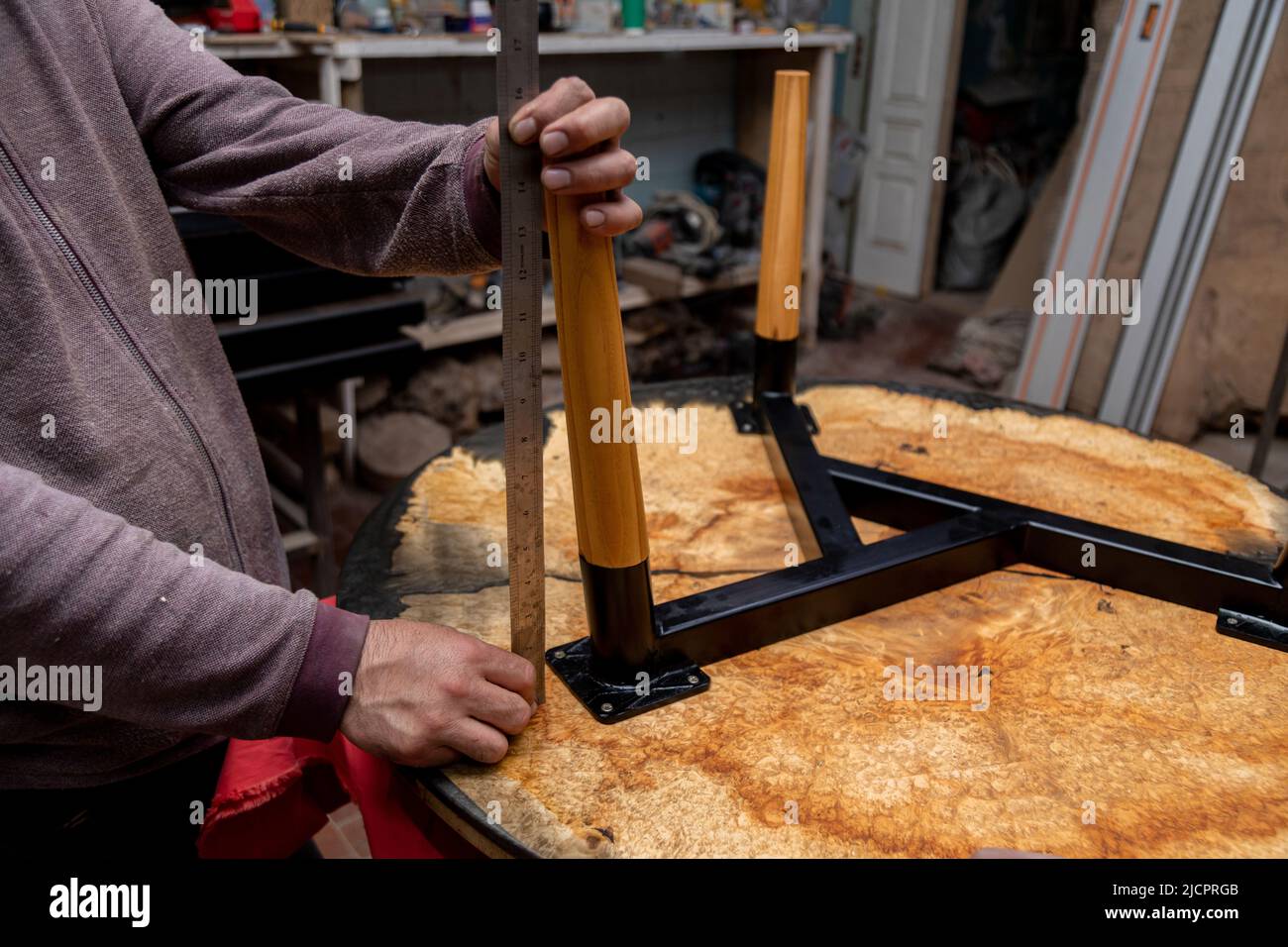 Closeup of person measuring the distance of a table leg with an iron ...