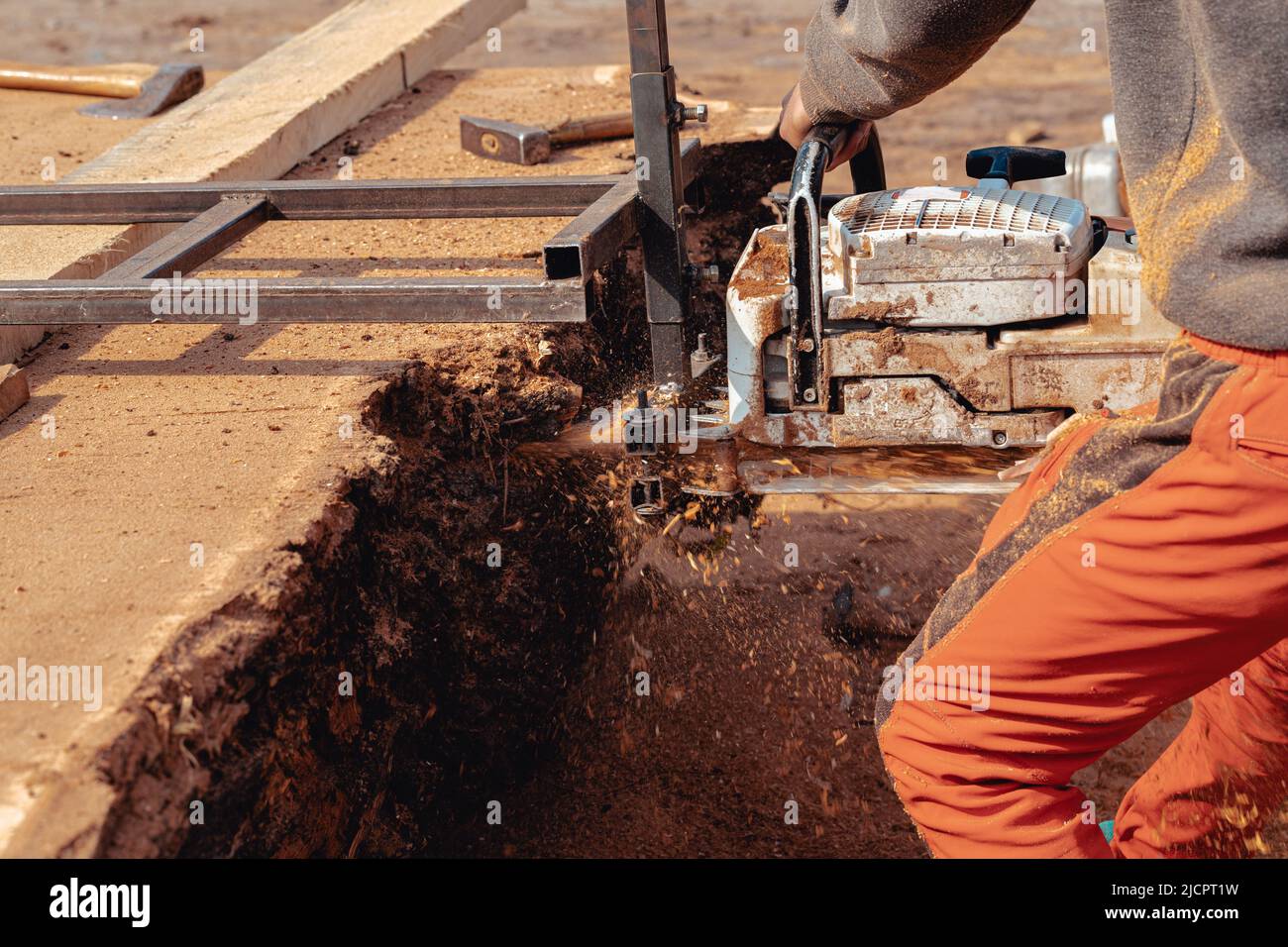 Closeup of lumberjack cutting tree trunk with giant chainsaw to make ...