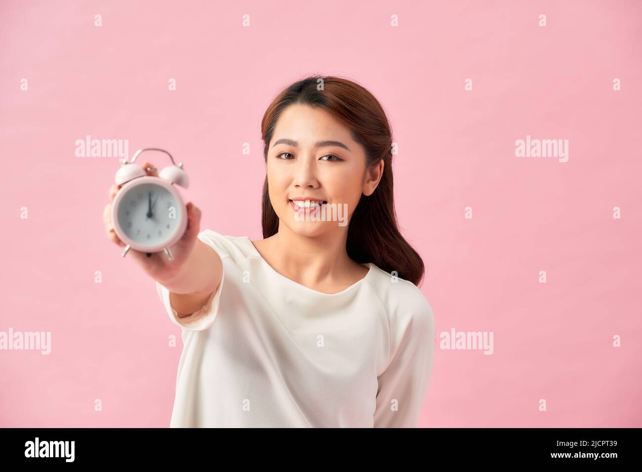 Cute laughing positive girl holding an alarm clock Stock Photo - Alamy