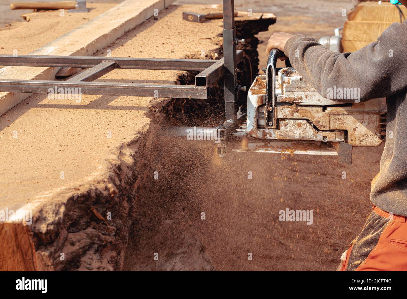 Closeup of lumberjack cutting tree trunk with giant chainsaw to make ...