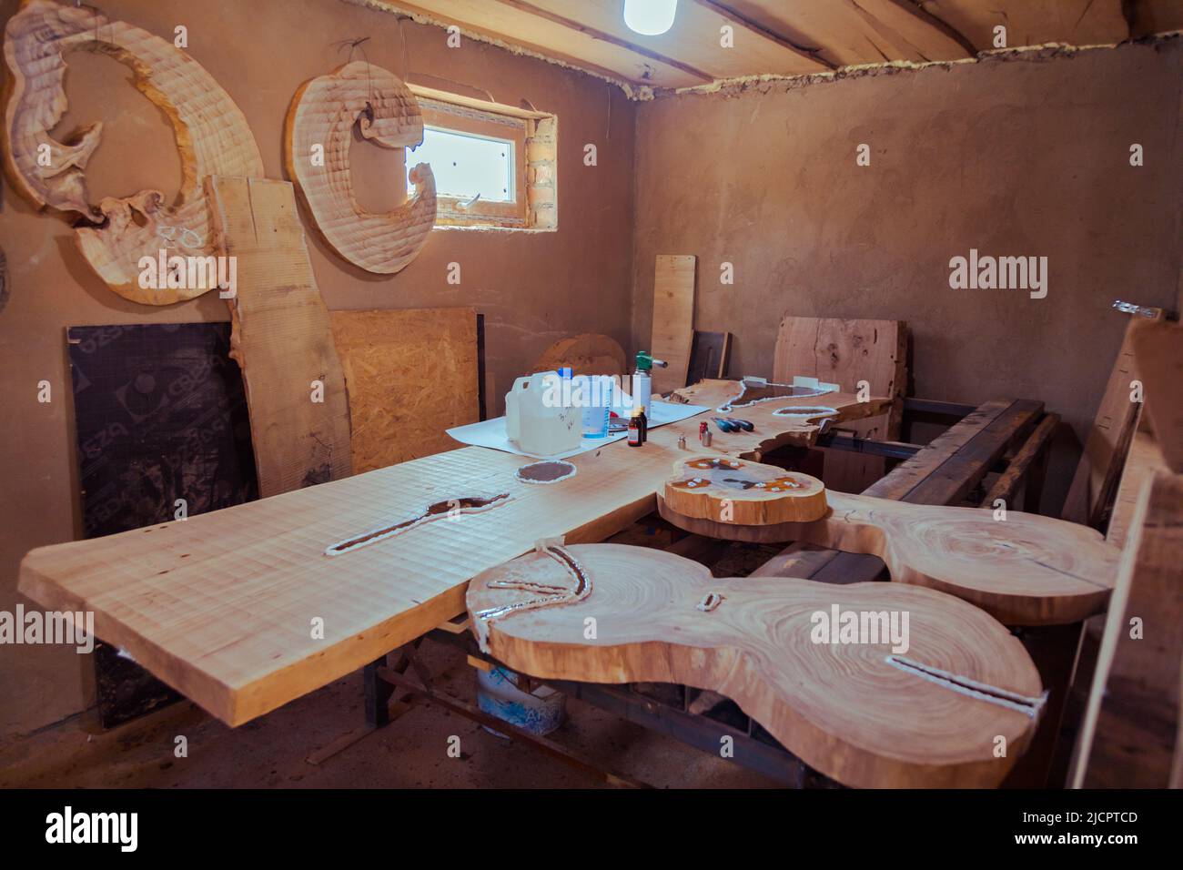 A view of an empty carpentry workshop with wood tables, slabs and tools ...