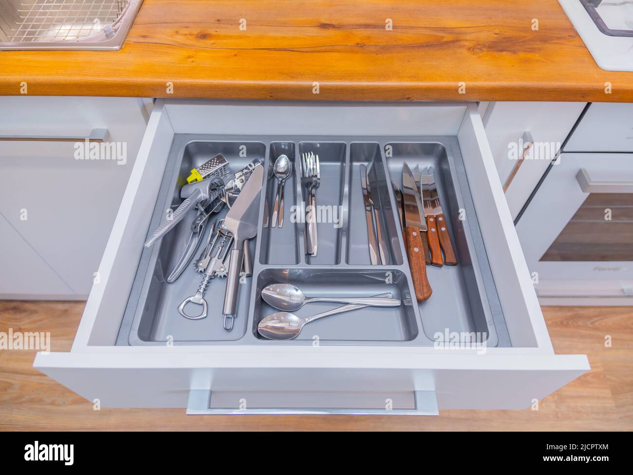 Open cupboard with cutlery inside Stock Photo - Alamy