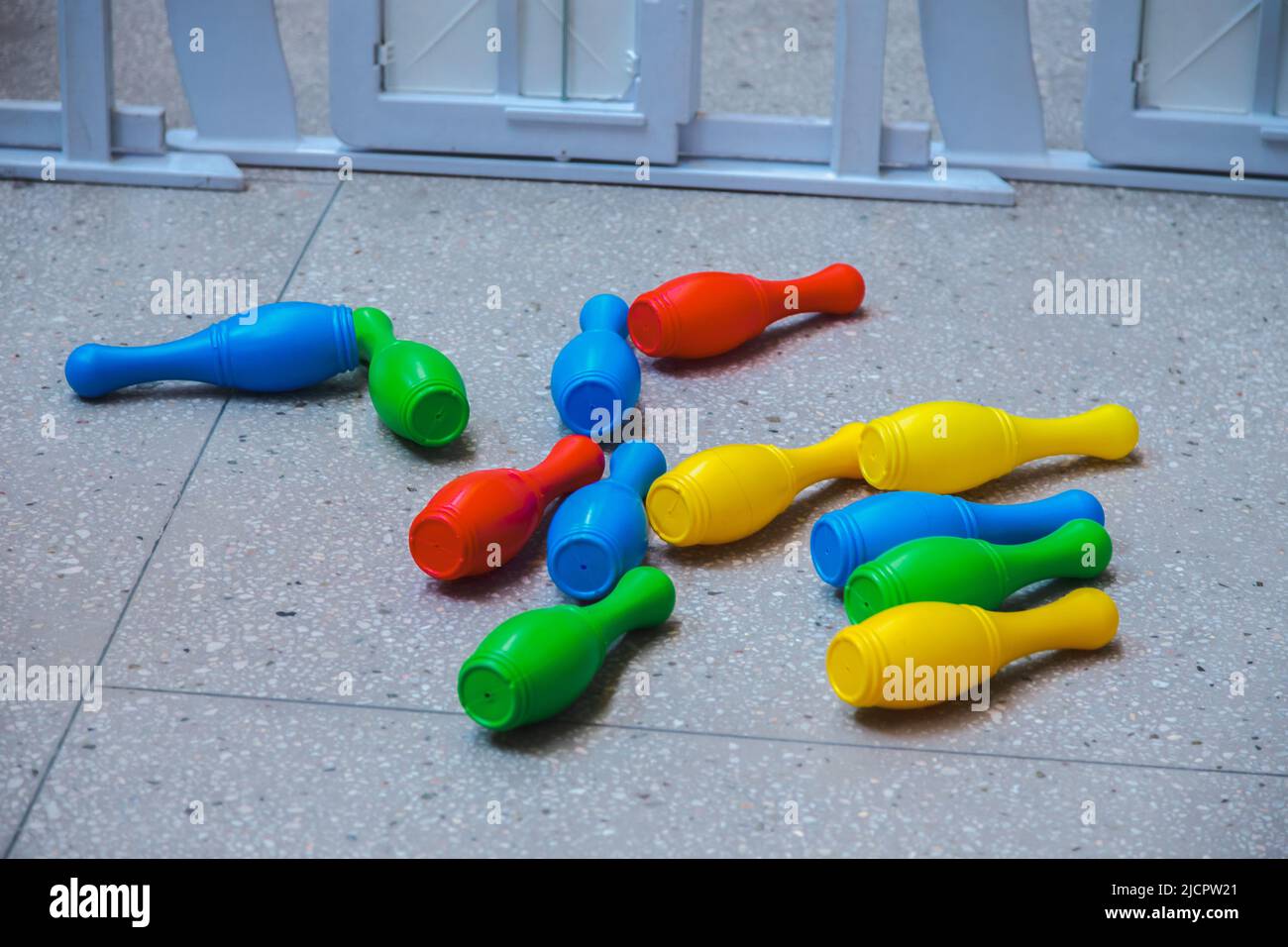 Set of colorful plastic toy bowling pins fallen on the floor Stock ...