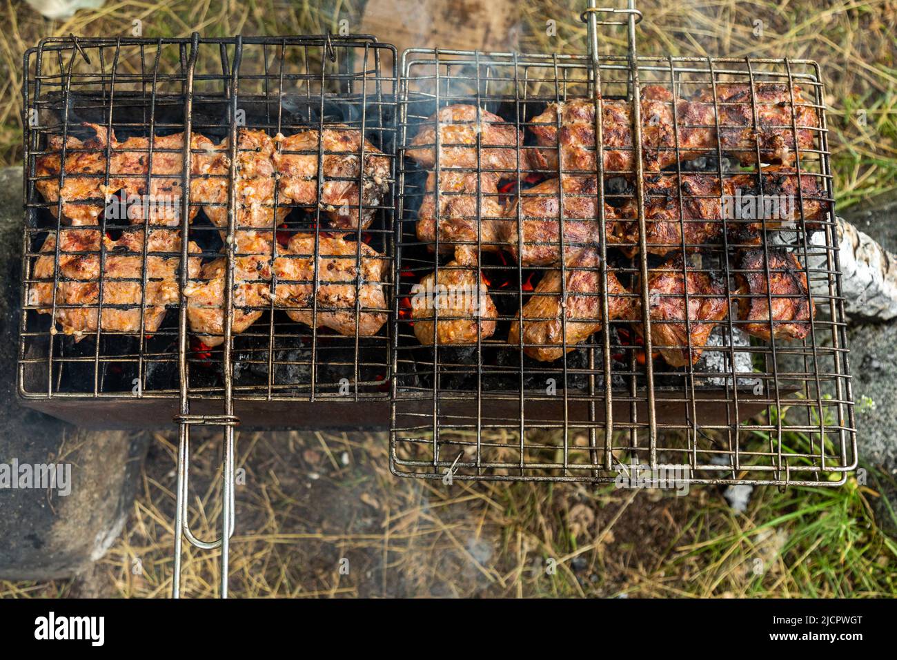 Top down view grill grate with beef meat on a brazier with flaming ...