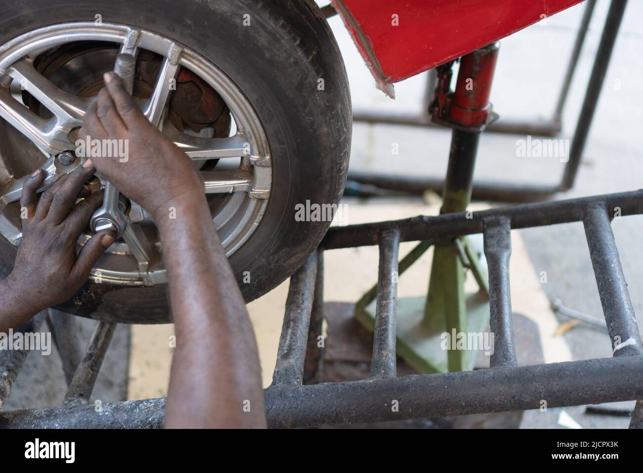 African mechanic's hands working on a car tire Stock Photo - Alamy