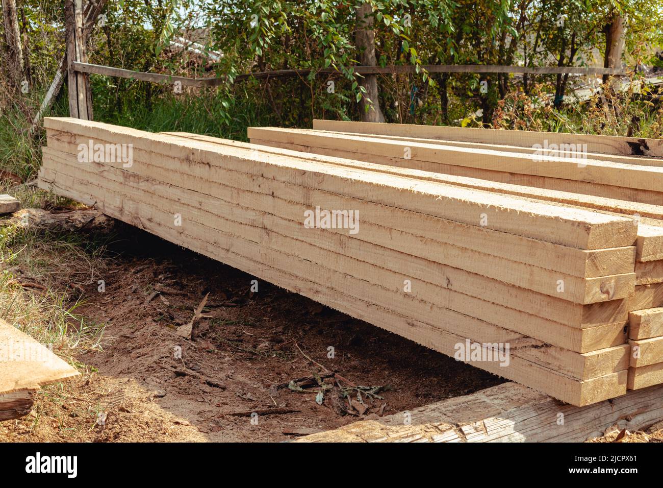 Stacked lumber. Folded wood.Closeup wooden boards. Wood planks stacked ...