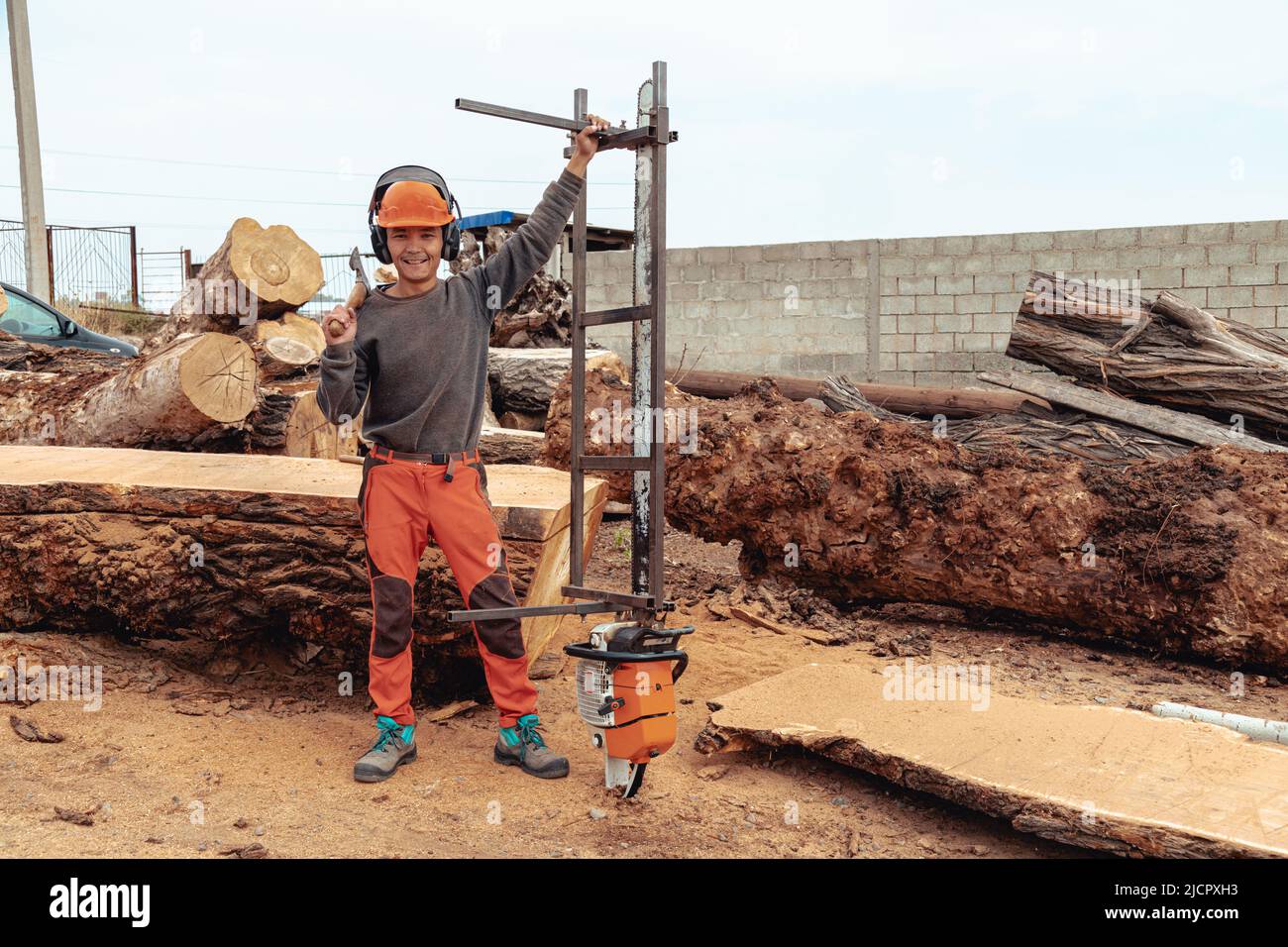 Caucasian lumberjack holding a giant chainsaw in the hand and smiling ...
