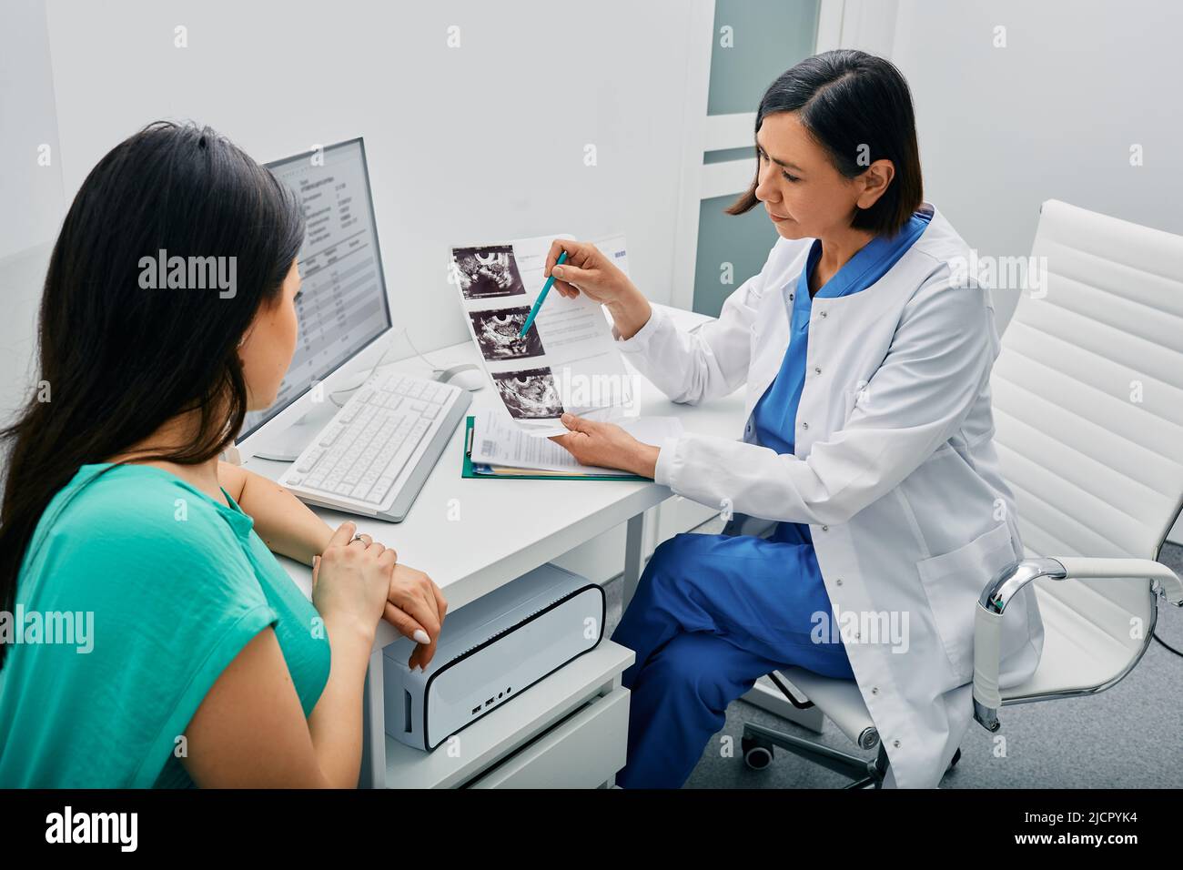 doctor and woman patient is talking in gynecological office during ...