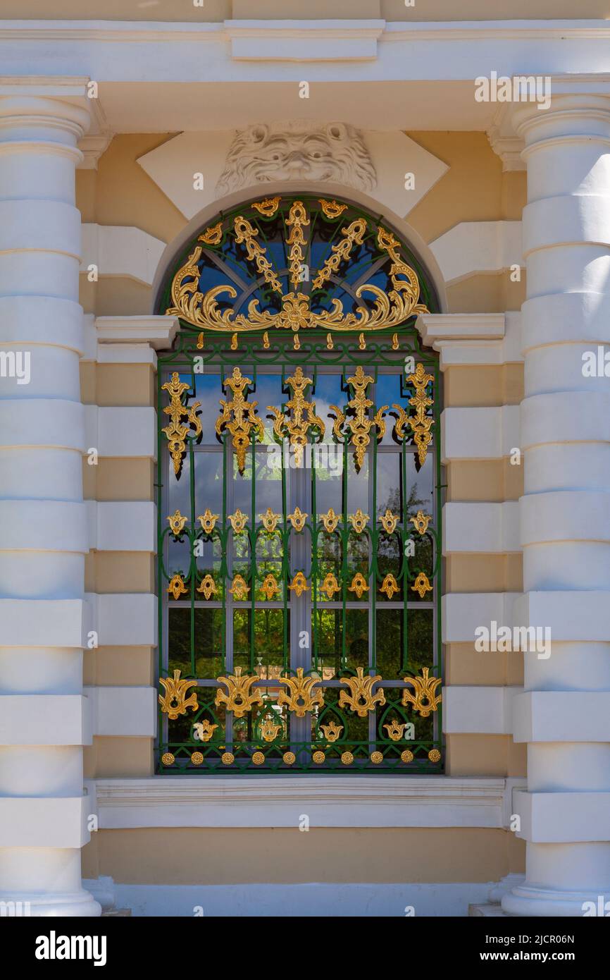 A picturesque window of an old mansion with columns and a gilded ...