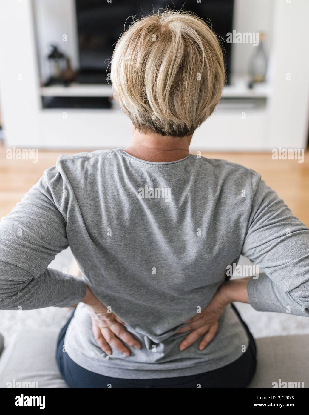 Elderly woman at home with lower back pain Stock Photo - Alamy