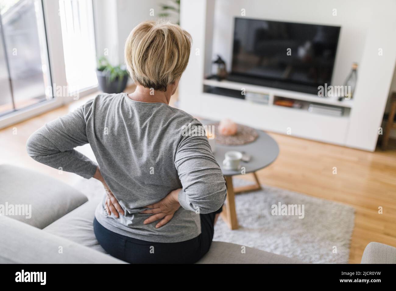 Elderly woman at home with lower back pain Stock Photo - Alamy