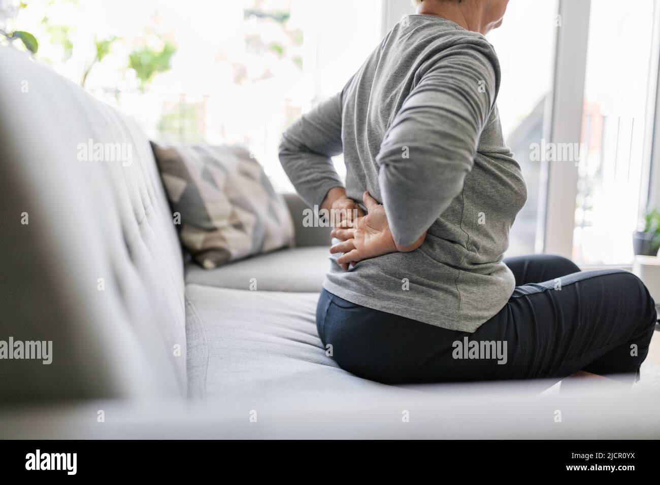 Elderly woman at home with lower back pain Stock Photo - Alamy