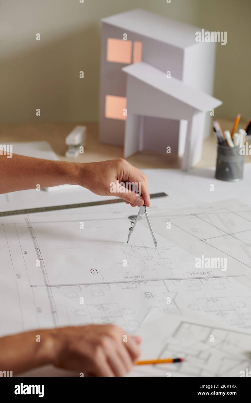 Civil engineer using compass when working on building blueprint Stock ...