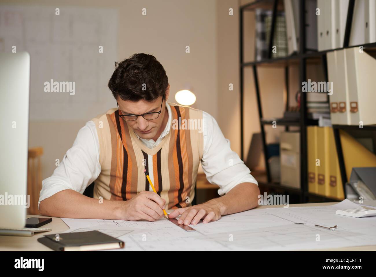 Architect concentrated on drawing construction plan of office building ...