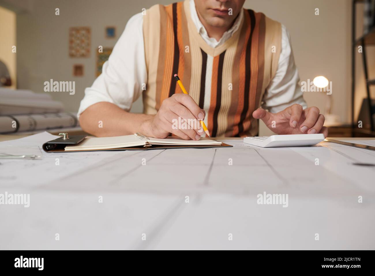 Engineer estimating project time and cost when working on blueprint for ...