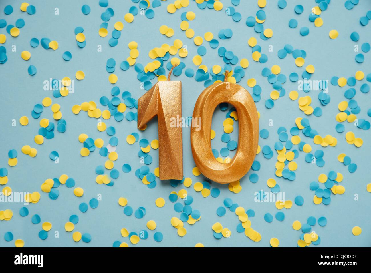 Number 10 ten golden celebration birthday candle on yellow and blue ...