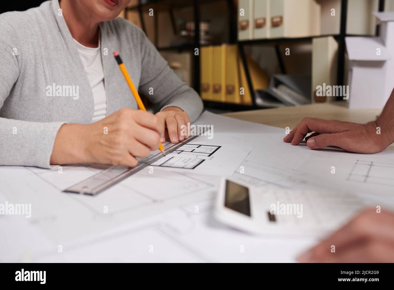 Architect measuring length of wall on house floor plan Stock Photo - Alamy
