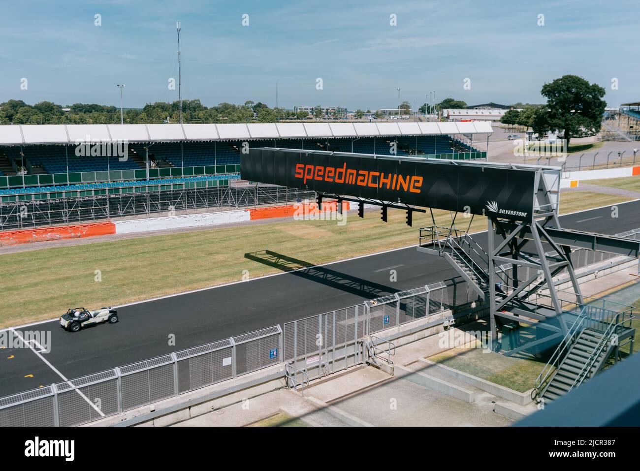 Vintage car speeds along Silverstone Circuit’s Hamilton Straight. Under ...