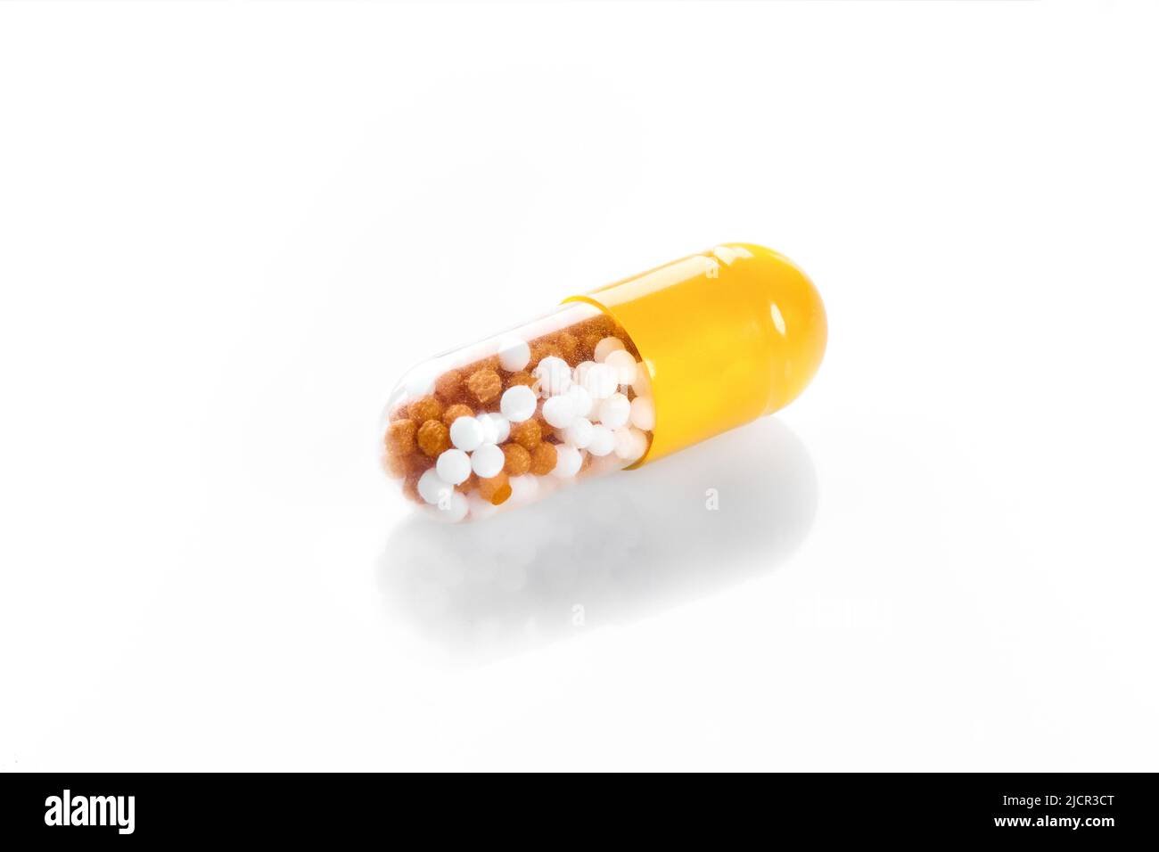 Macro yellow medical pill tablet with pellet, microgranules isolated on ...