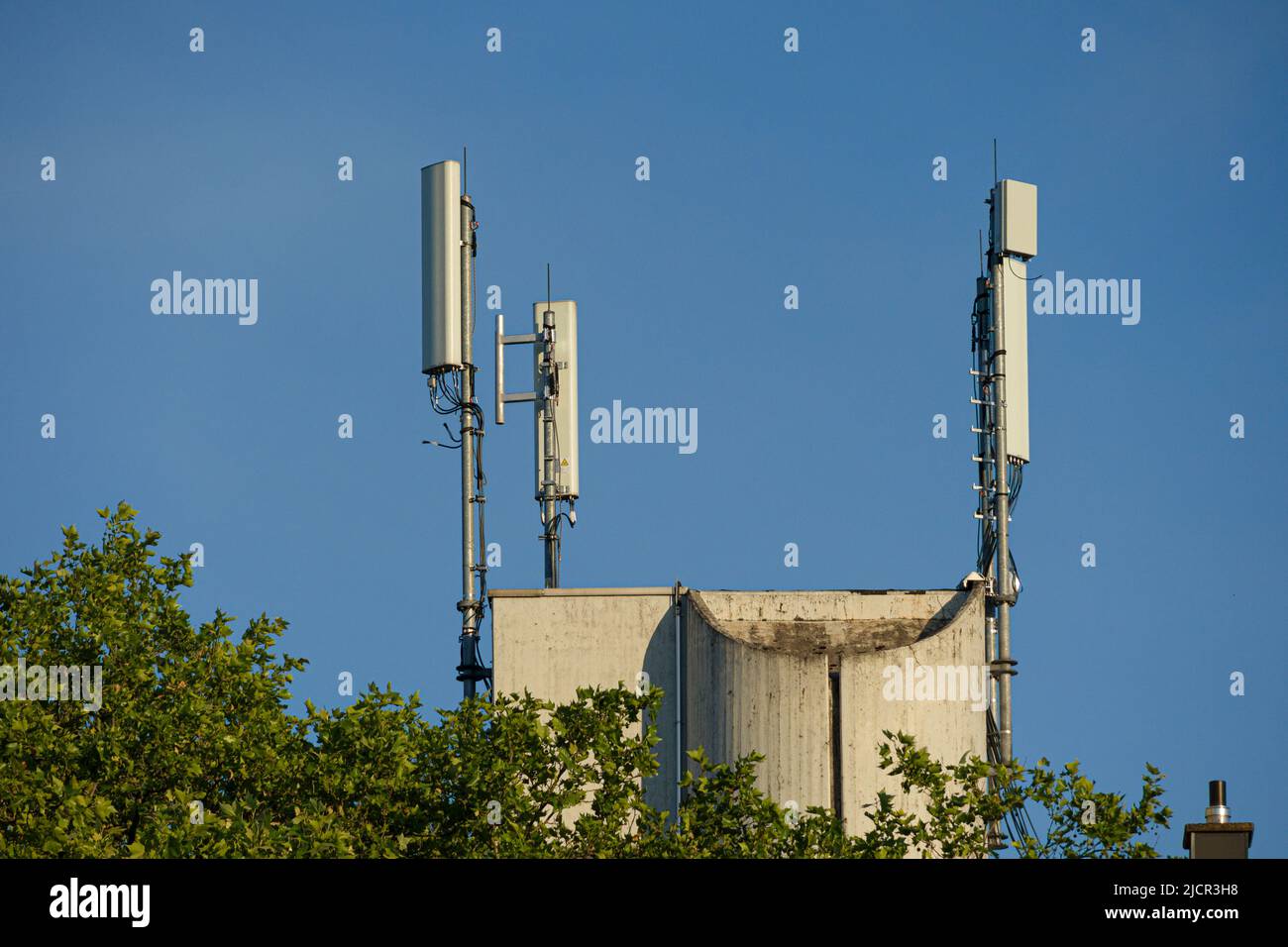 Three antenna masts for mobile radio communications on a roof top Stock ...