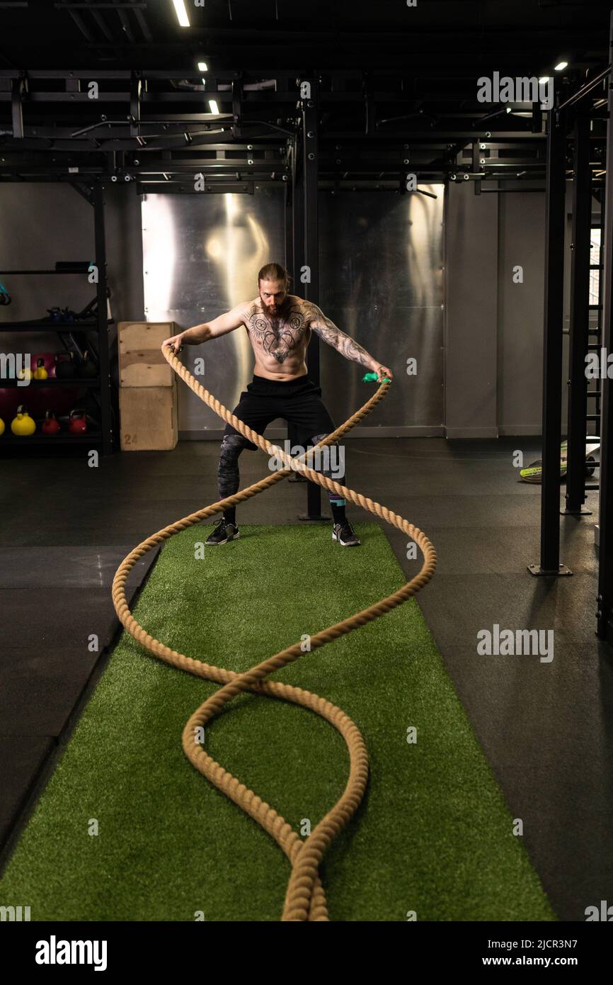 Rope training man warehouse fitness gym muscular exercising exercise ...