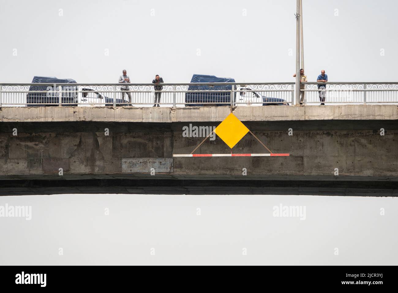 People standing and looking over the hand rail of a Bridge over the ...