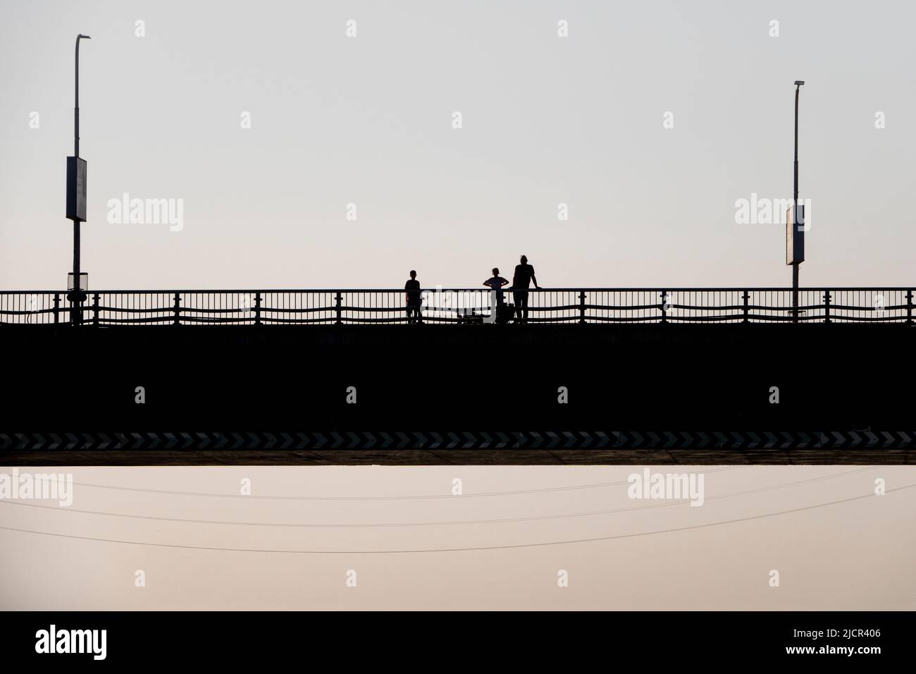 People standing and looking over the hand rail of a Bridge over the ...