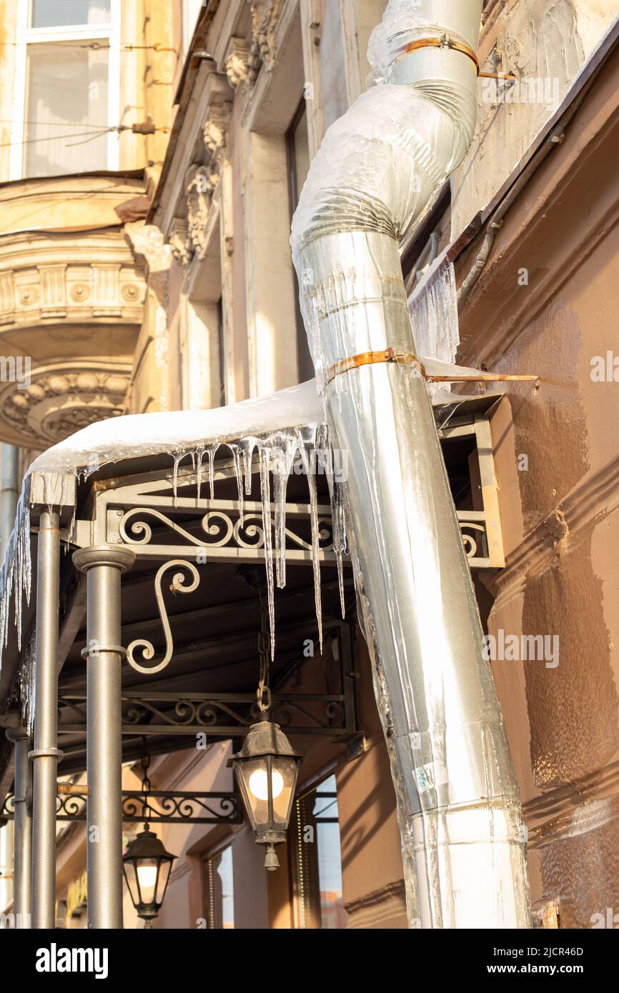 Sharp icicles a lot and melted snow hanging from eaves of roof and ...