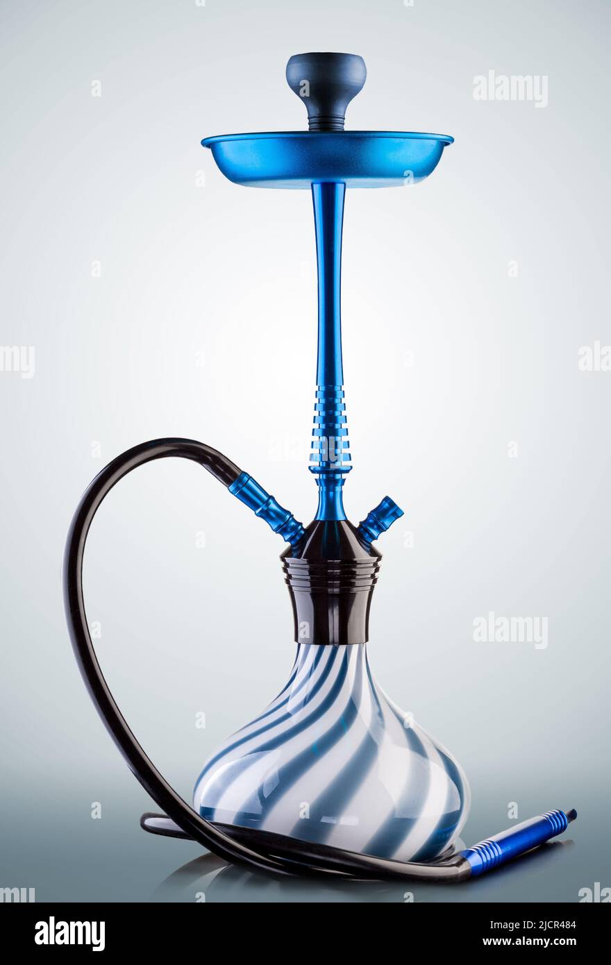 Blue hookah with black rubber tube and blue and white flask on light ...