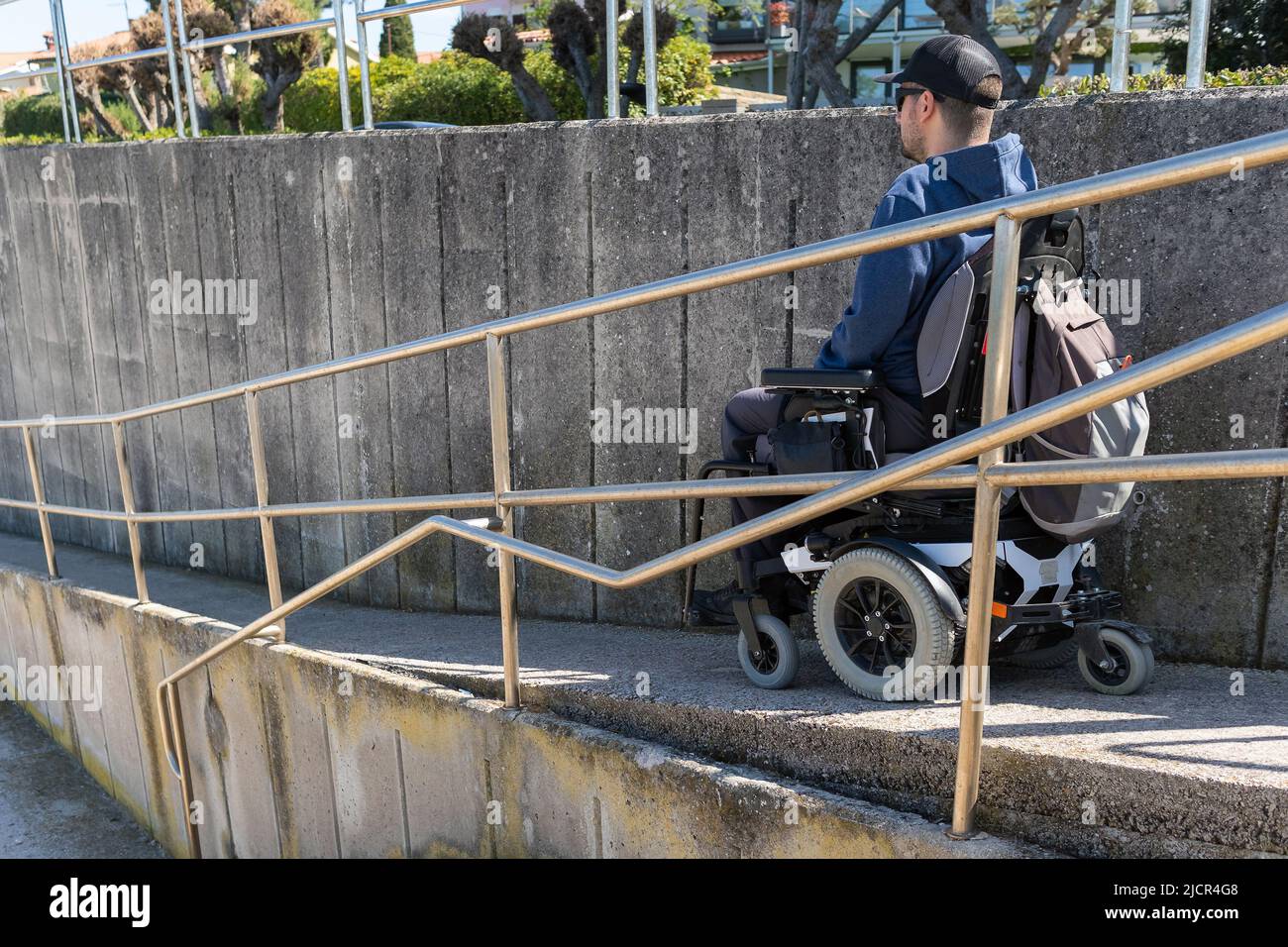 Man on a wheelchair use accessible ramp Stock Photo - Alamy