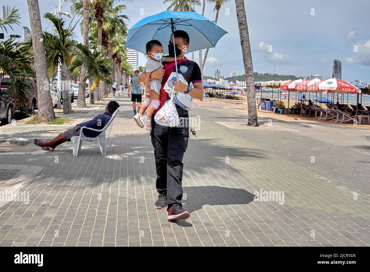 Man carrying baby. Father carrying his infant child and holding a sun ...