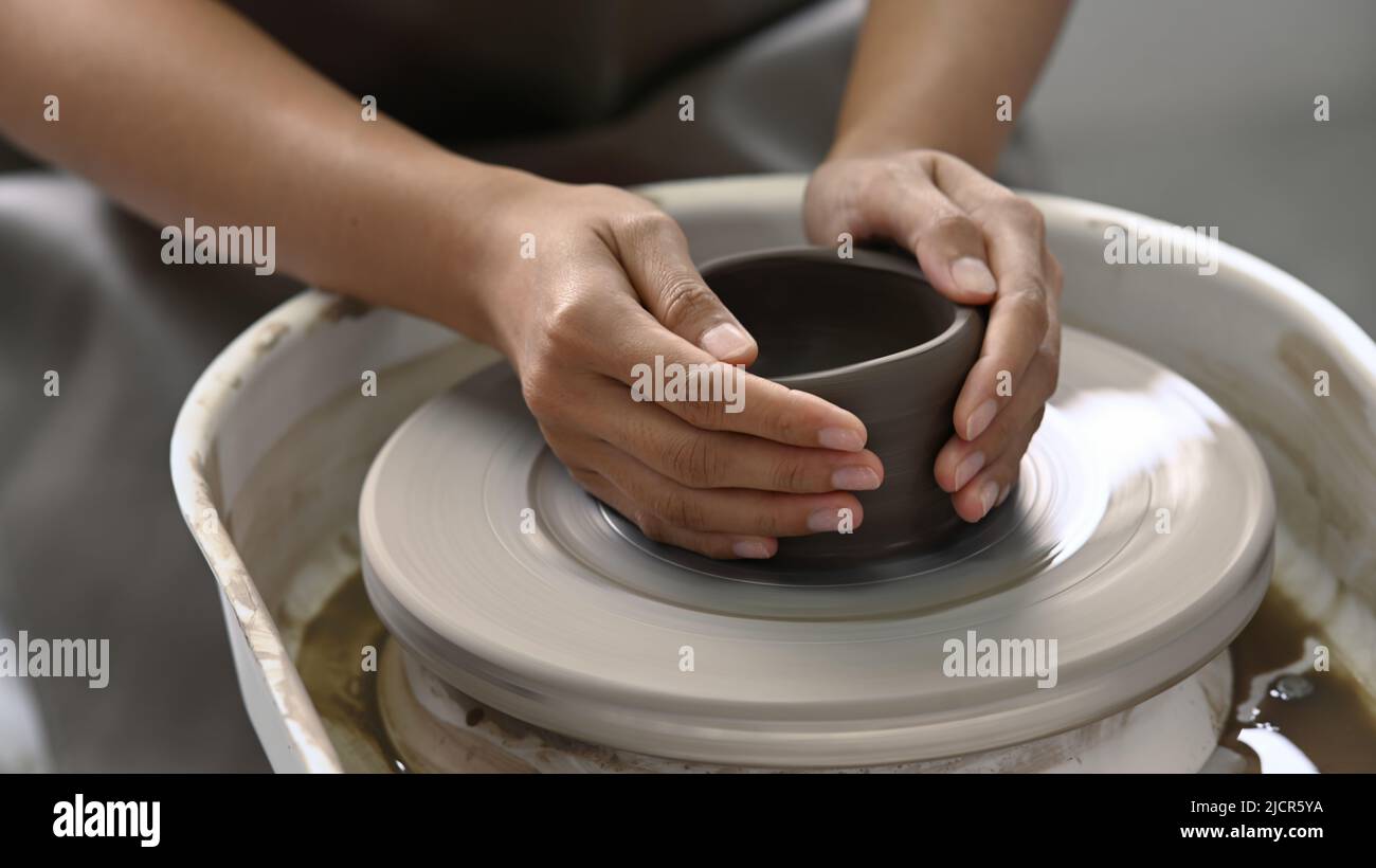 Unrecognized ceramicist creating handicraft crockery on the pottery ... Unrecognized ceramicist creating handicraft crockery on the pottery ...