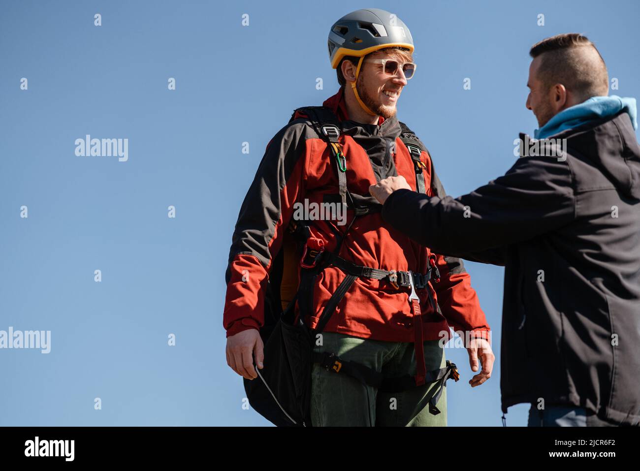 Man helping paragliding pilot to prepare for flight Stock Photo - Alamy
