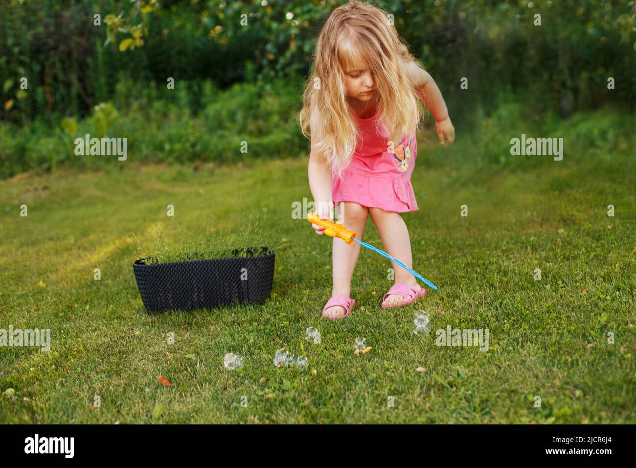 Cute little girl is blowing a soap bubbles Stock Photo - Alamy
