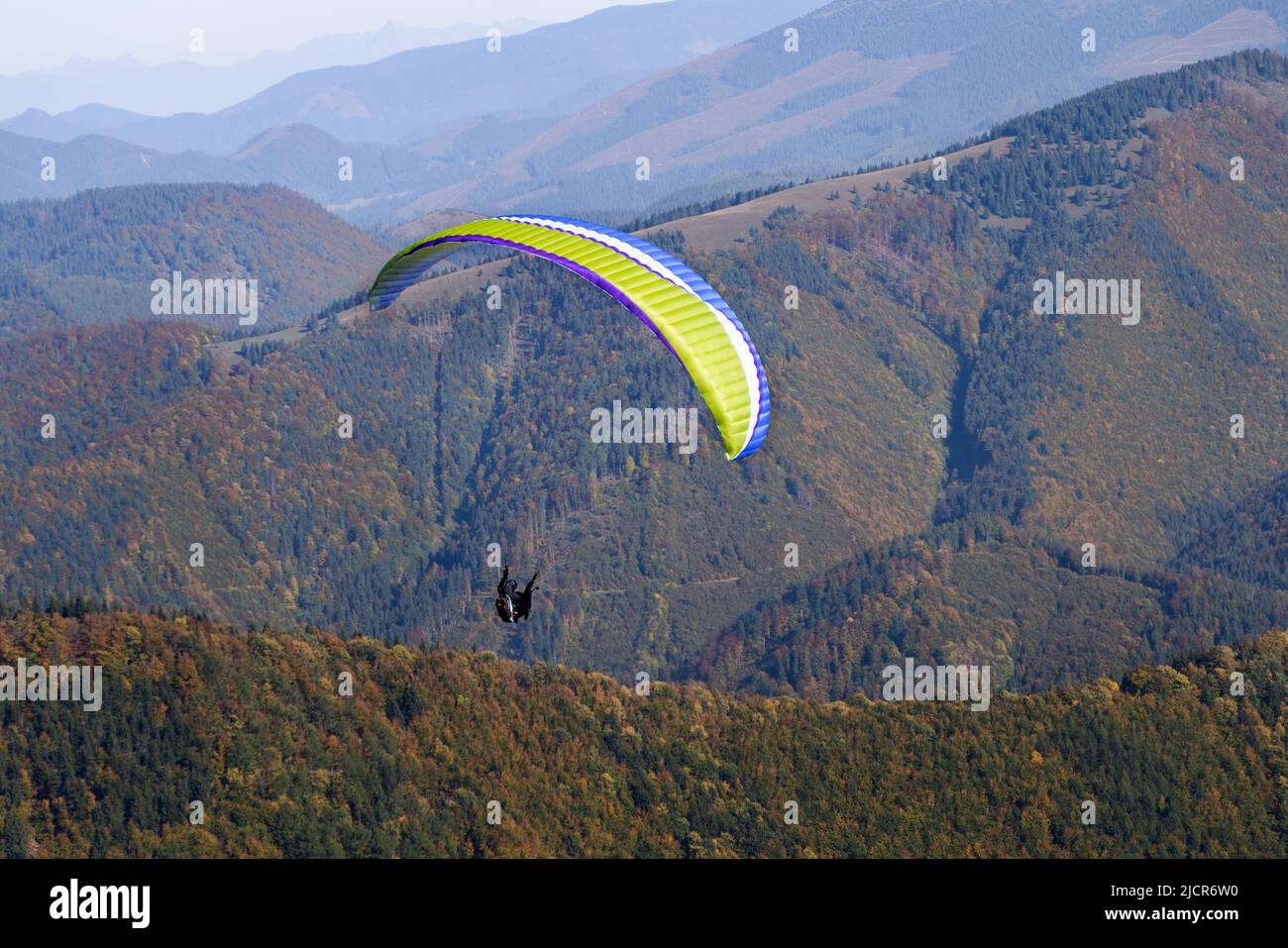 Paragliders flying in the blue sky with mountain in background Stock ...