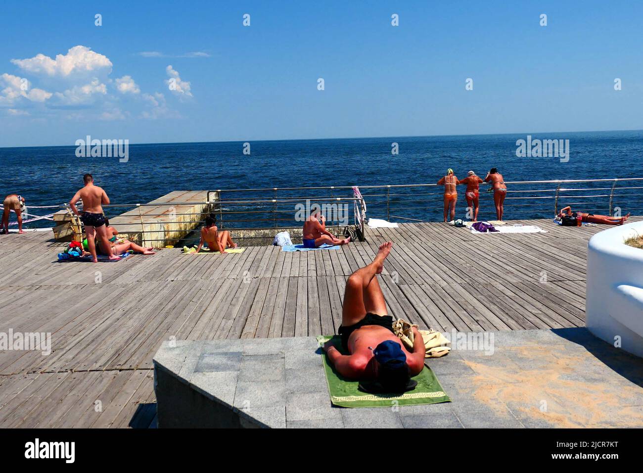 ODESA, UKRAINE - JUNE 13, 2022 - People tan at an embankment of the ...