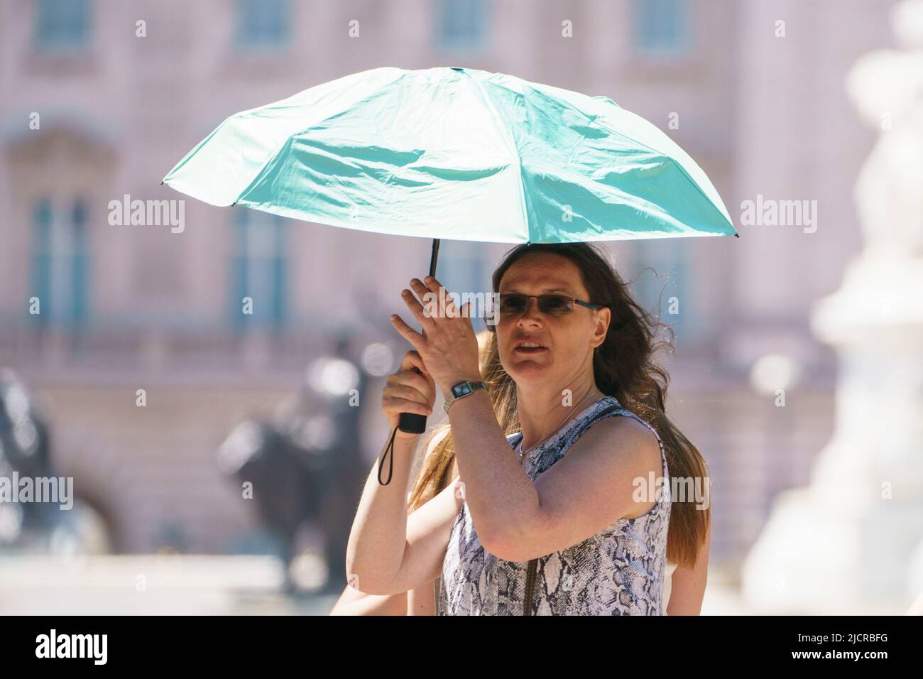 Woman uses an umbrella to shade herself from the hot hi-res stock ...