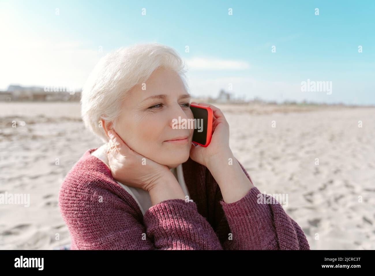 Calm elderly lady calling on the smartphone outdoors Stock Photo - Alamy