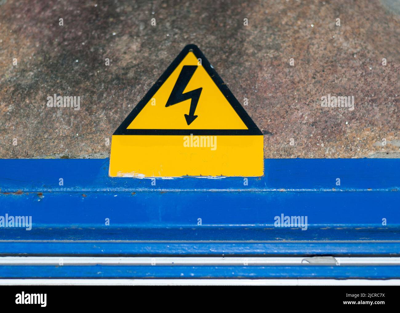 Yellow signal warning of danger due to high voltage on a blue ...