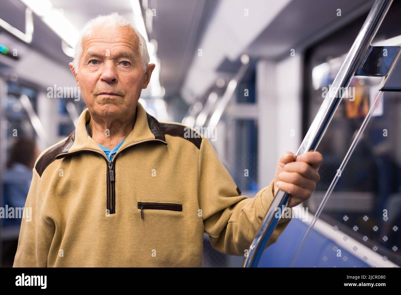 Old man standing in subway car Stock Photo - Alamy