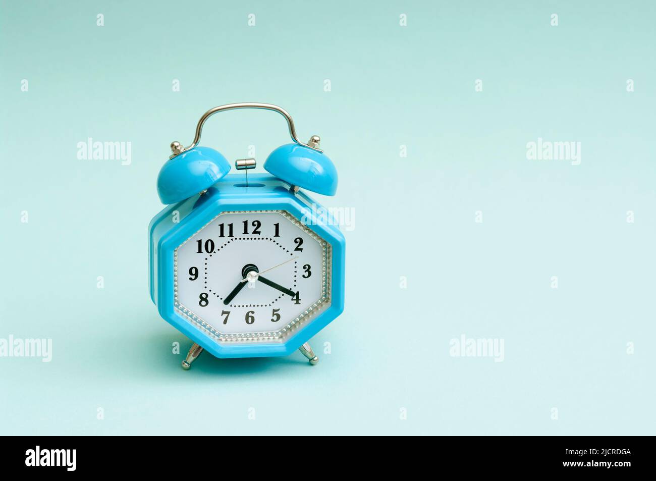 Colorful vintage style analog alarm clock on blue background with free ...