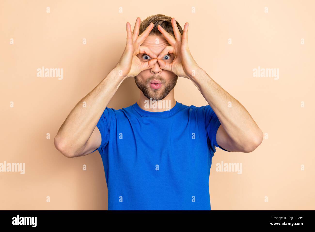 Photo of young man have fun fooling show fingers okey symbol binoculars ...
