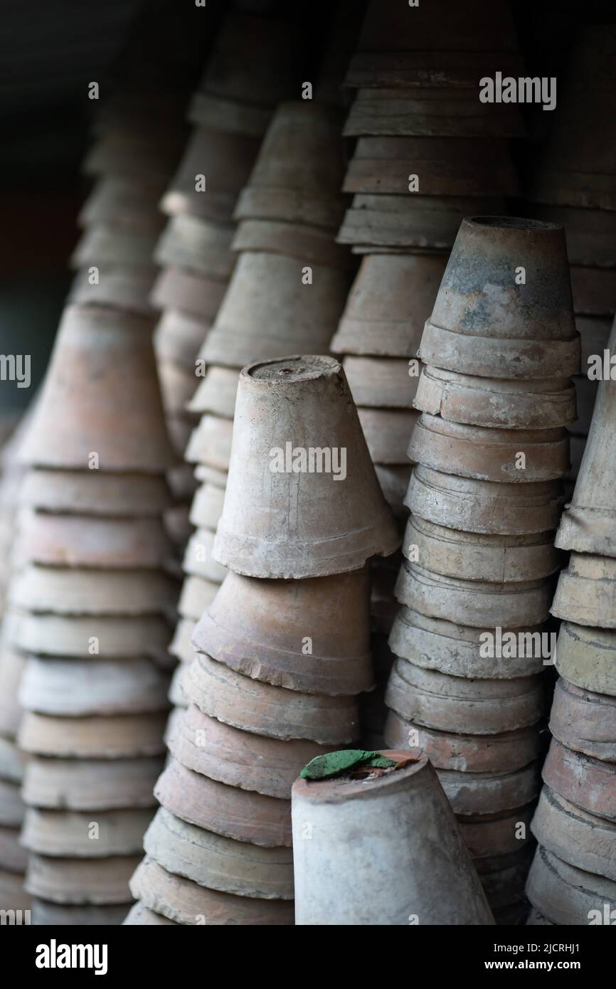 Closeup of stacks of old used weathered terra cotta flower pots in ...