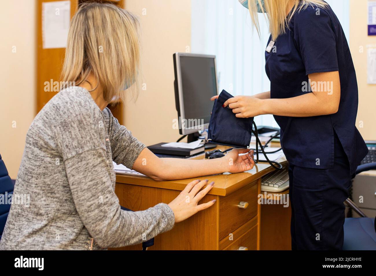 nurse in measures the pressure of the patient with a tonometer in the ...
