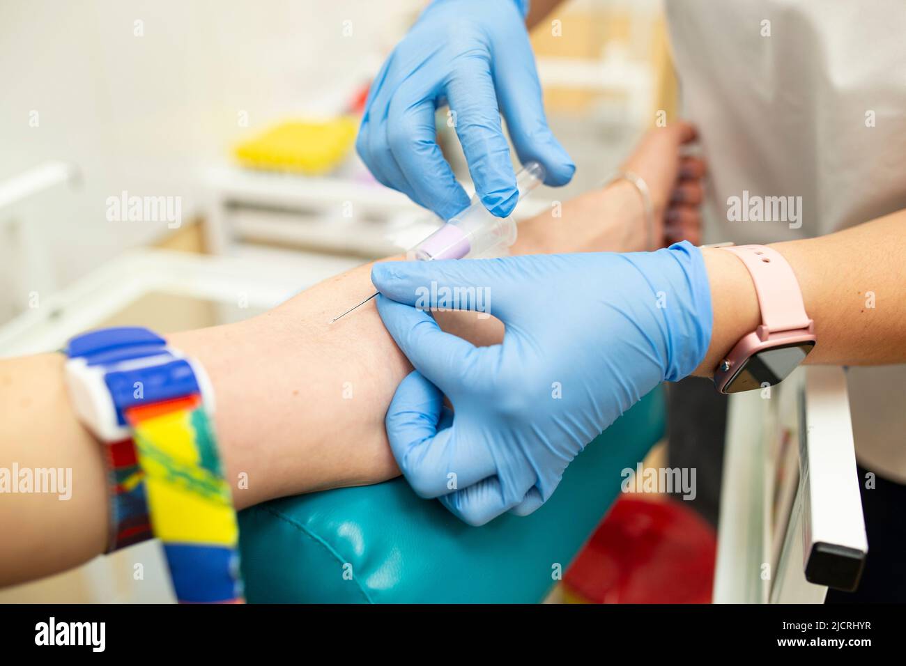 The nurse holds a syringe and makes an intravenous injection to the ...