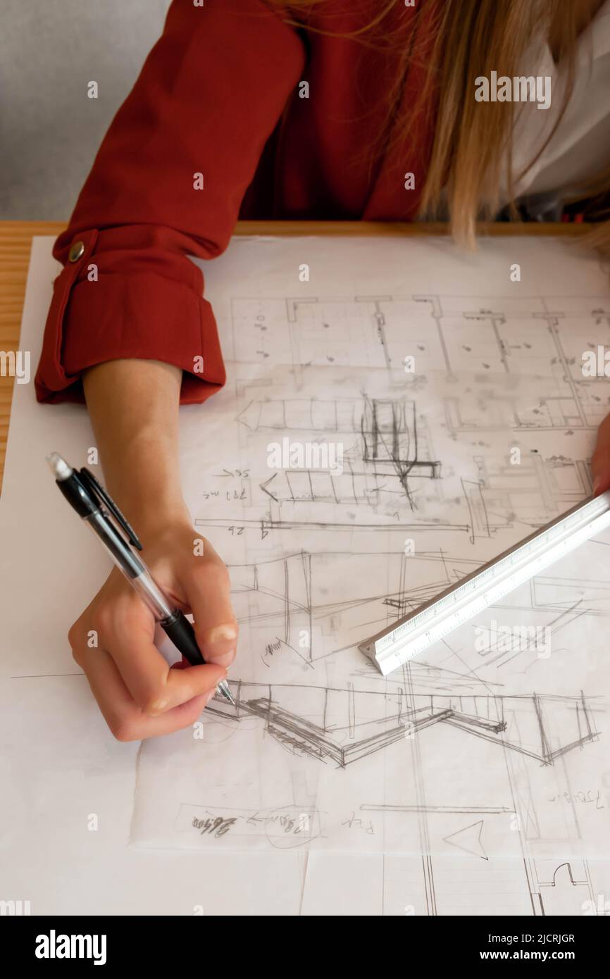 Close up of woman wearing orange outfit while drawing architecture ...