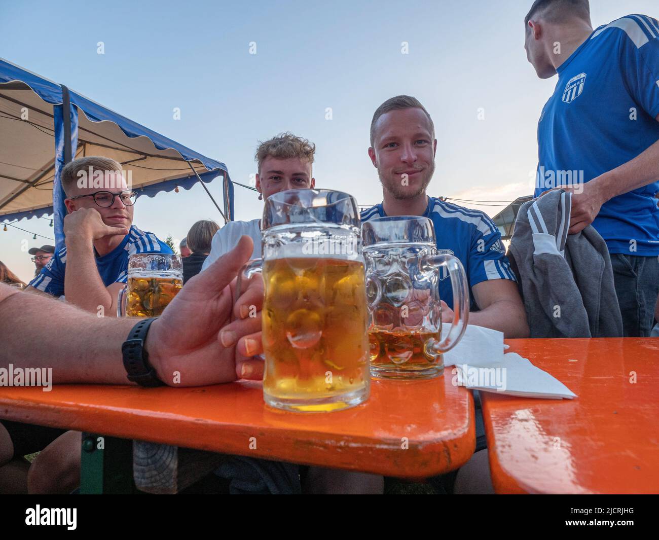 Members of a sports team drink beer at a common table during a holiday ...