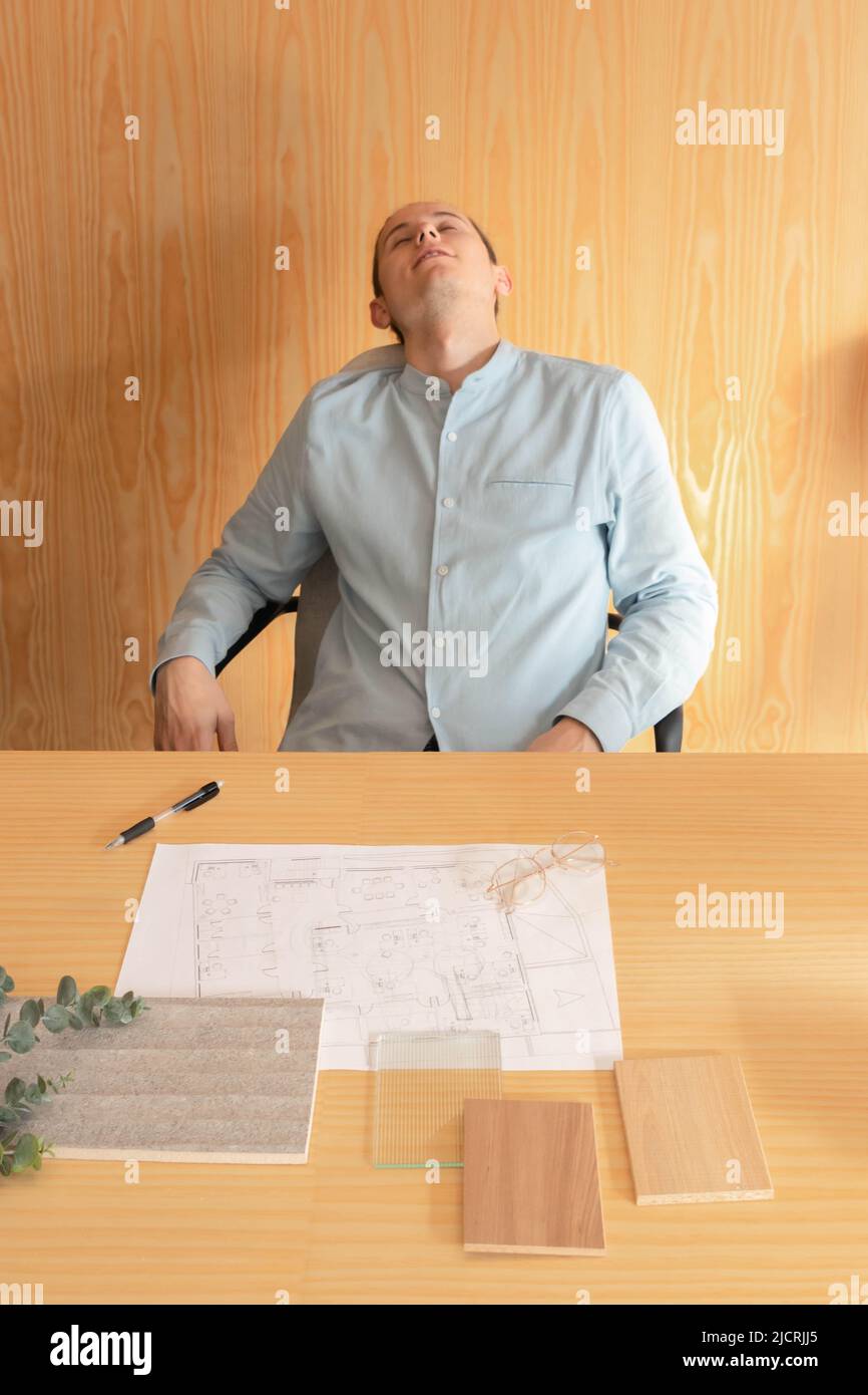 Sleepy and exhausted young man working in interior design and architect ...
