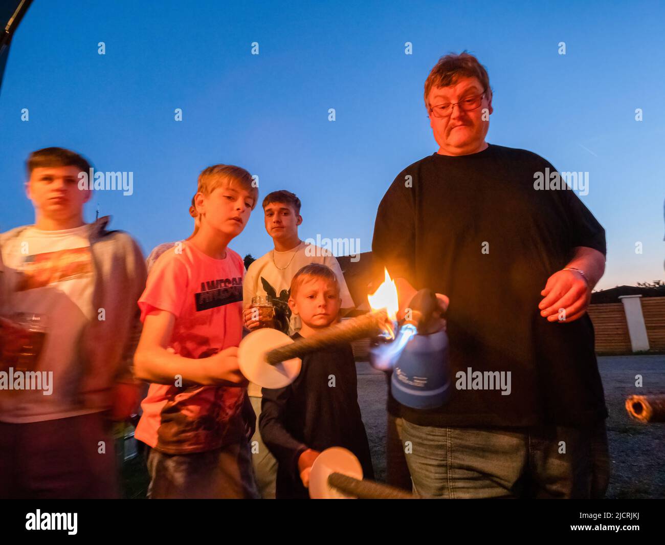 Man using a gas burner kindles torches for children. Bavaria is a part ...