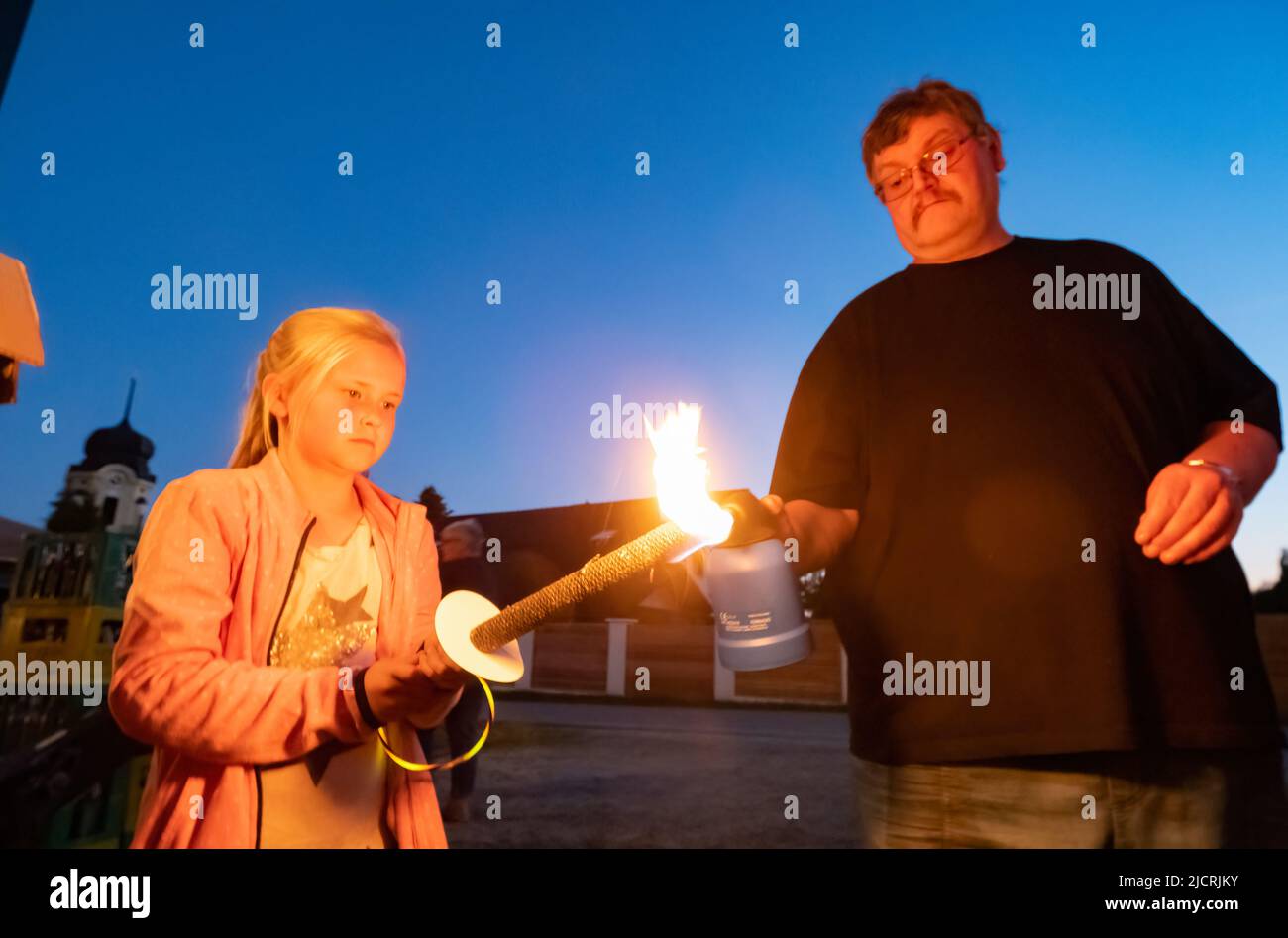 Man using a gas burner kindles torches for girl. Bavaria is a part of ...